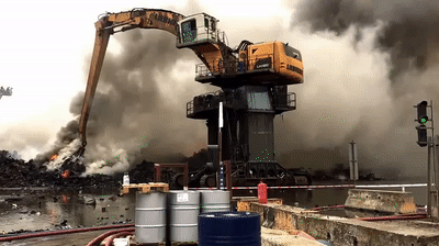 Fire at a Scrap yard using excavator to put it out on Make a GIF