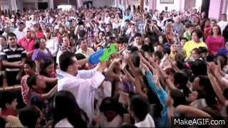 Mexican priest uses watergun to spray holy water on Make a GIF