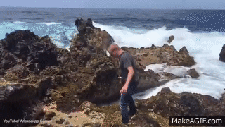 Man gets hit by giant wave and loses everything in his bag on Make a GIF
